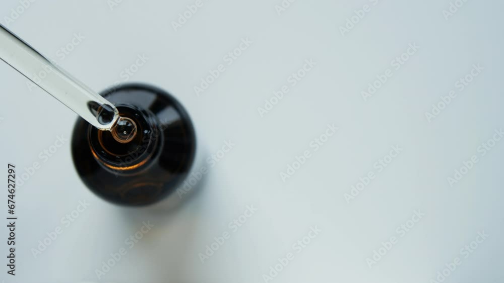 Brown Bot tles of essential oil. Top view. Drop falls from a pipette ...