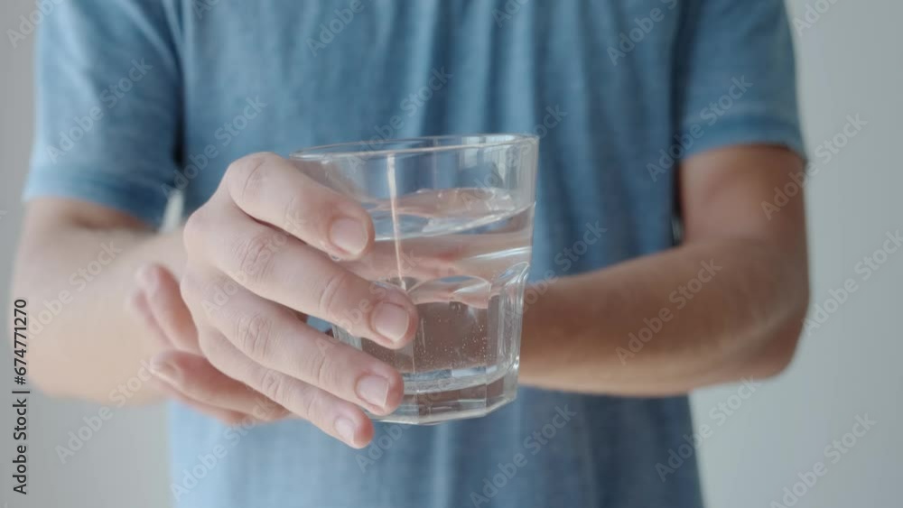 Man holding drinking glass with shaking hands suffering from tremor ...