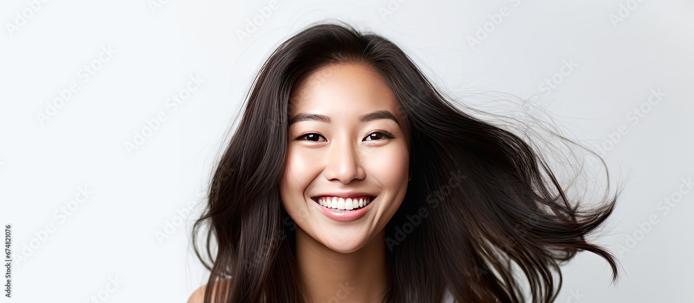 The Asian woman poses for a portrait in front of a white isolated ...