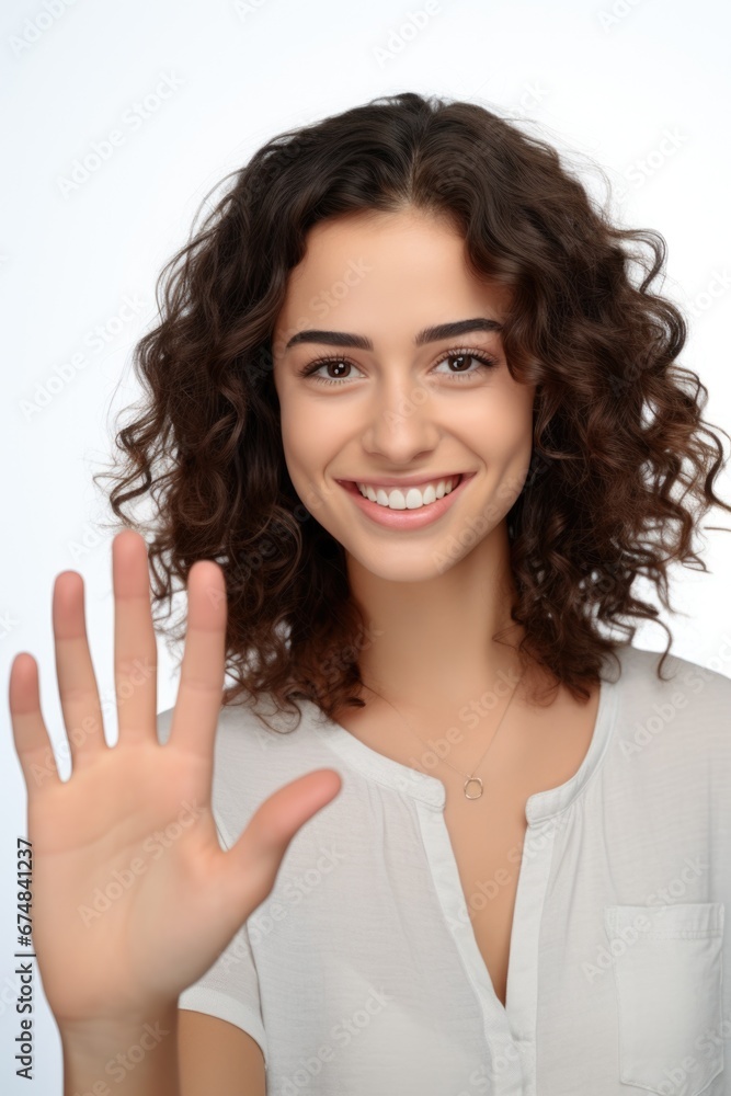 A beautiful young woman is pictured making a stop sign with her hand ...