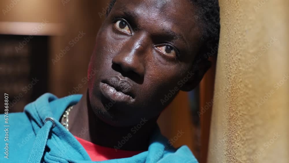 depressed black man leaning against a wall in the night with anguished ...