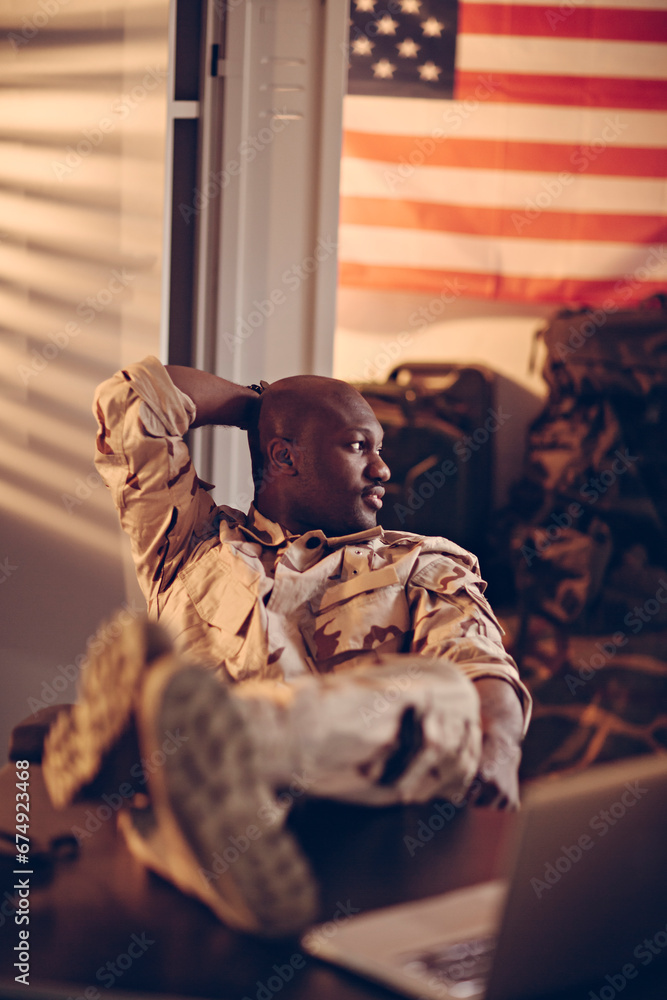 Soldier taking break in army base American flag background Stock Photo ...