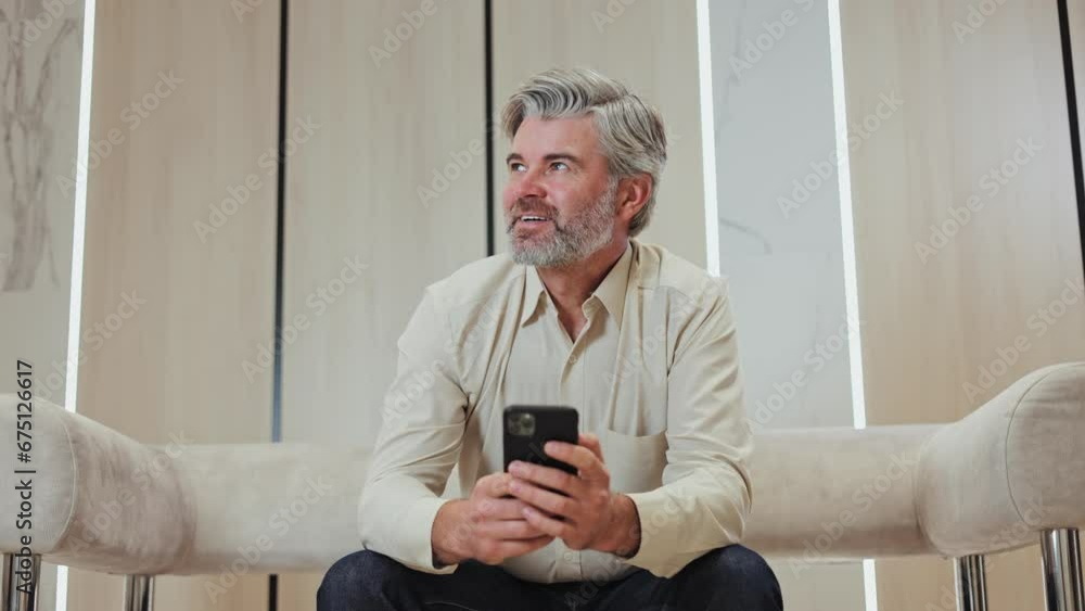 Low angle view of handsome man with grey hair and beard smiling while ...