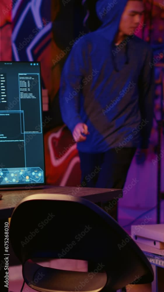 Vertical video Asian hacker arriving in graffiti painted underground ...