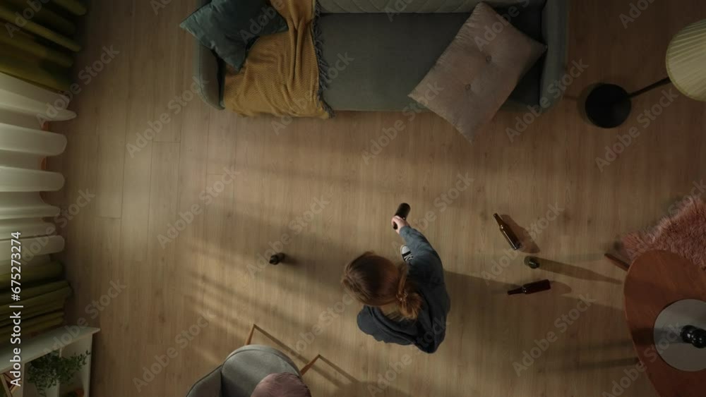 Top view of a drunk woman in the living room. The woman staggers around ...