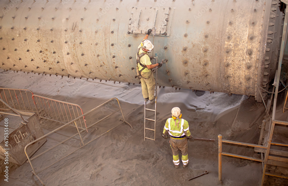 Workers are repairing the grinding mechanism in the workshop of a ...