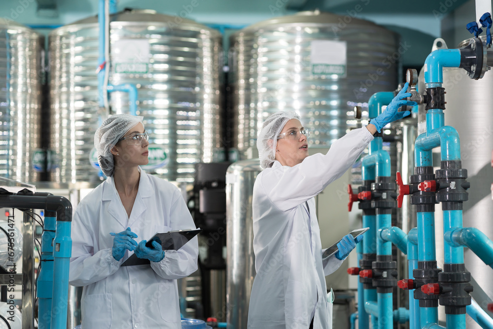 Two female worker wearing uniform, hairnet working and checking of ...