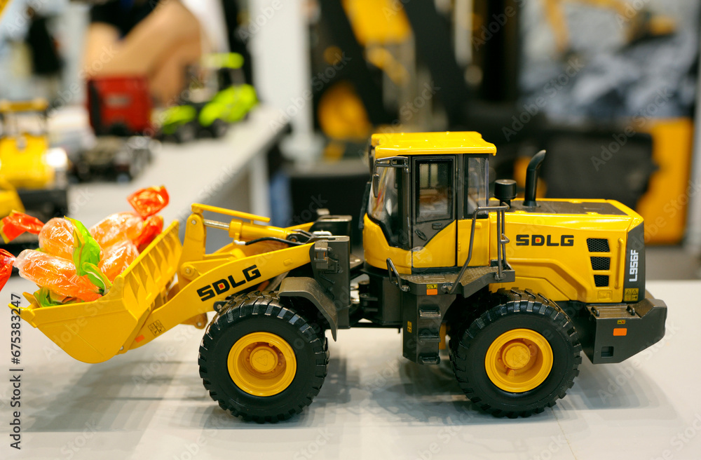Toy model of a tractor backhoe loader made by SDLG placed on a table ...