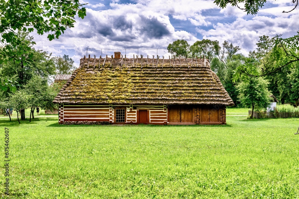 A fragment of a traditional Polish house with a thatched roof and a ...
