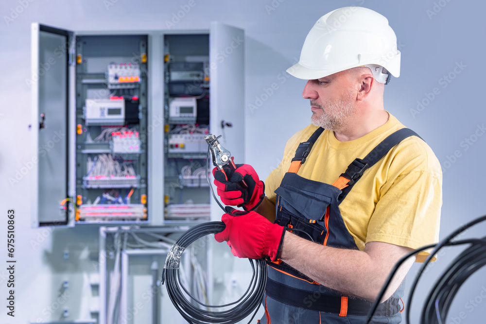 Man electrician with wire. Electrical panel. Electrical installation ...