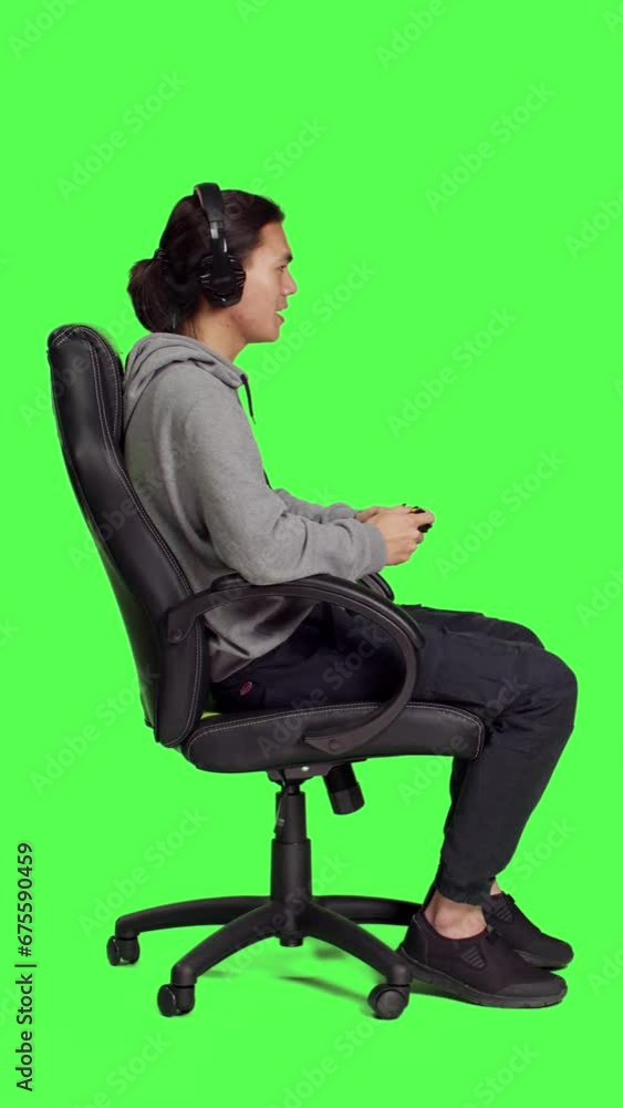 Profile of asian man using controller for contest, sitting on chair ...