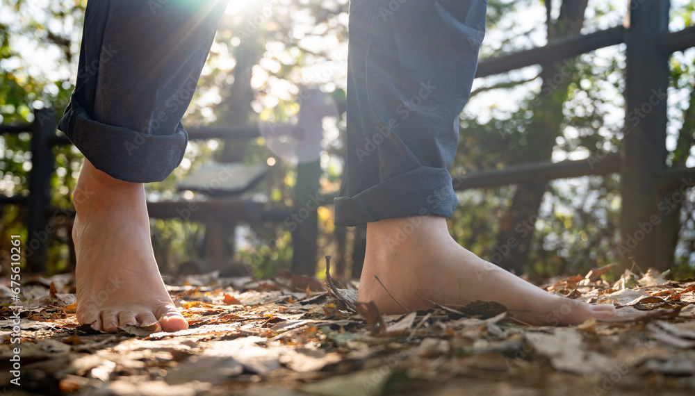 A man walking barefoot on a fallen leafy road. Healthy lifestyle ...