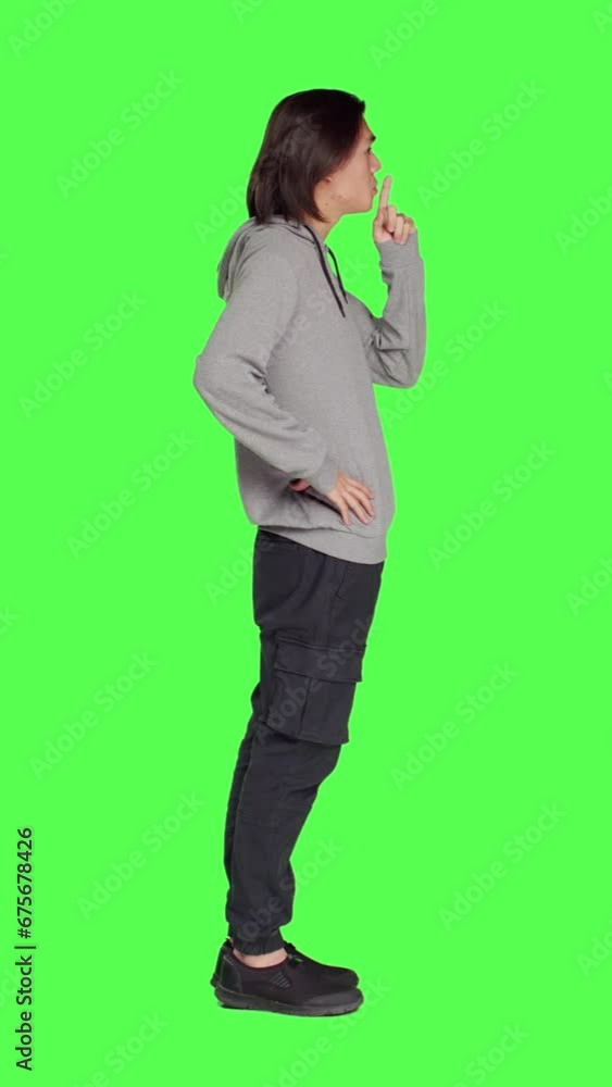 Profile of adult doing hush secret sign over greenscreen, expressing ...