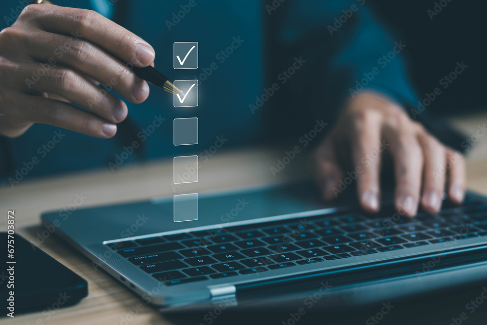 the person ticks the checkmark in the box on the laptop on the list of ...