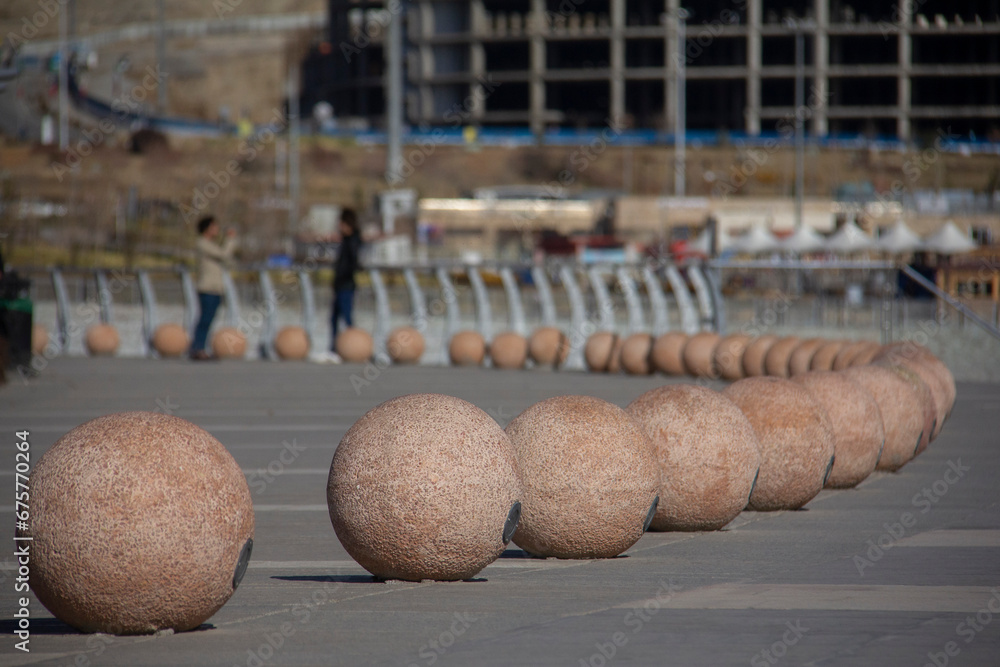 round stone balls arranged in a circle on the edge of a lake in the ...