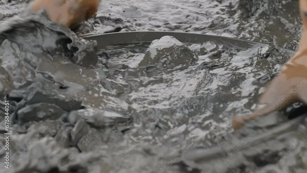 Using a panning technique to separate rocks from the valuable gold ...