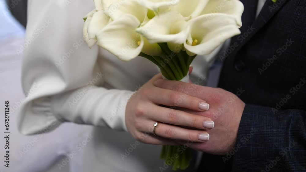Young bride and groom hug and hold hands. The newlyweds caress each ...