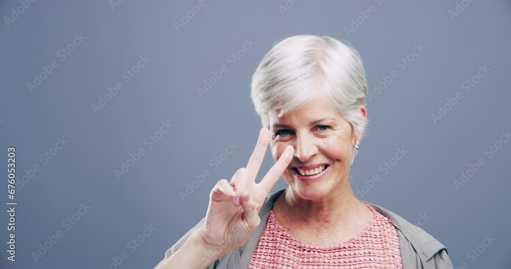 Happy, mature woman and hands for peace, sign or freedom emoji in gray ...