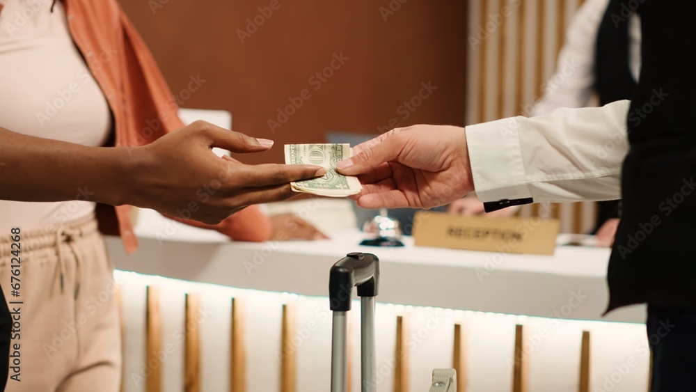 Close up of thankful hotel guest tipping helpful bellboy after ...