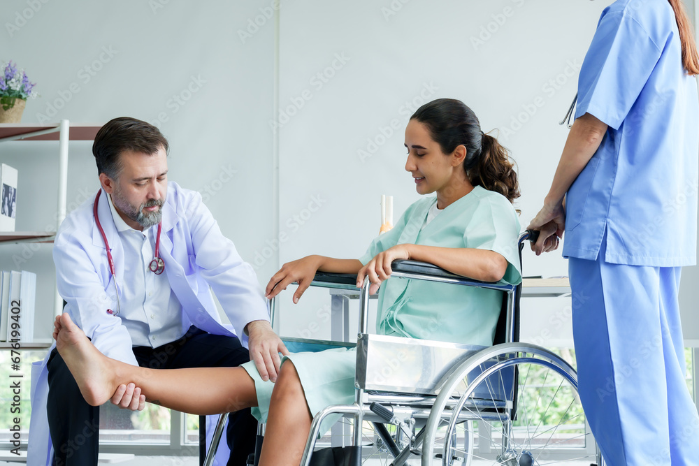 orthopedic specialist Lifting leg of female patient sitting in a ...