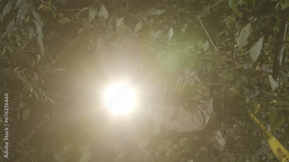 Medium shot of Black male police detective holding flashlight and gun ...