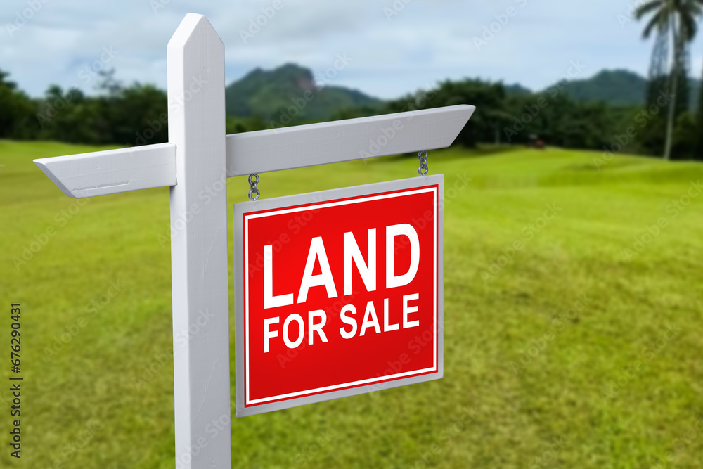 Land for sale sign in green grass field for housing development and ...
