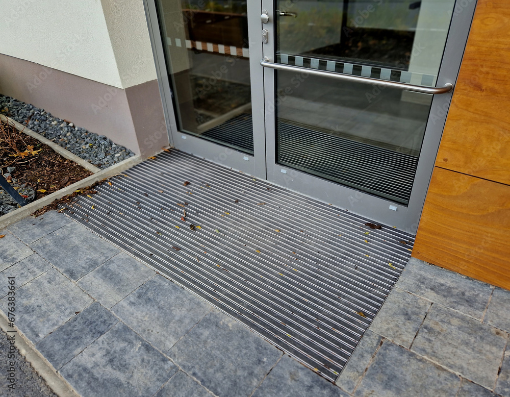 industrial mat cleaning zones at the entrance to the building. A black ...