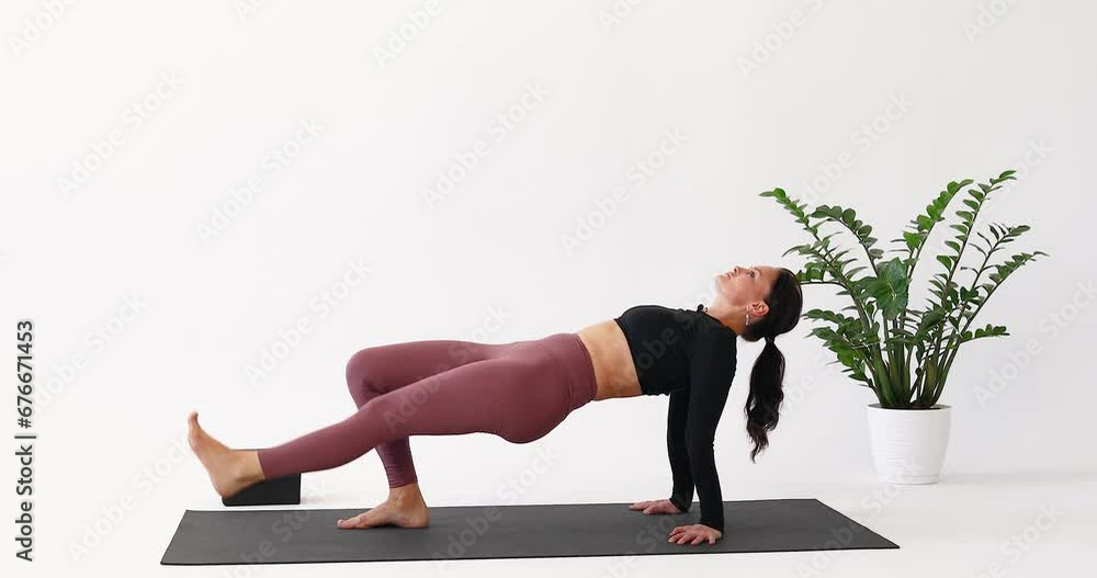 Video Stock Yoga brunette woman performs a variation of the ...