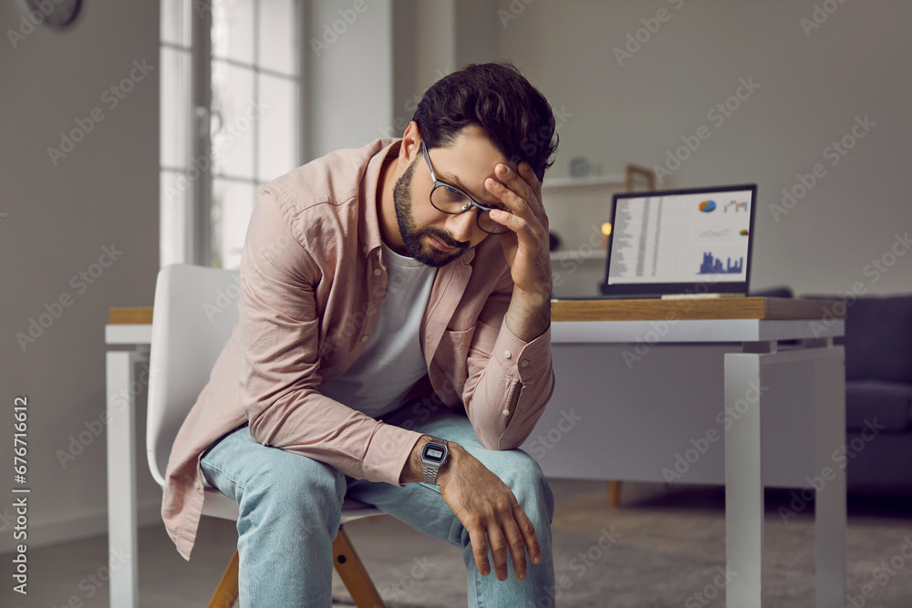 Stressed business man experiencing a burnout, sitting on a chair by his ...