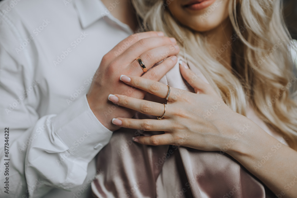 Hands with gold rings on the fingers of an embracing man and woman ...