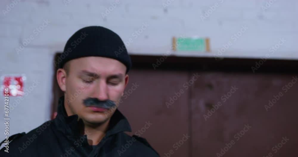 Portrait of brutal security guard in black uniform, tight hat, looks ...