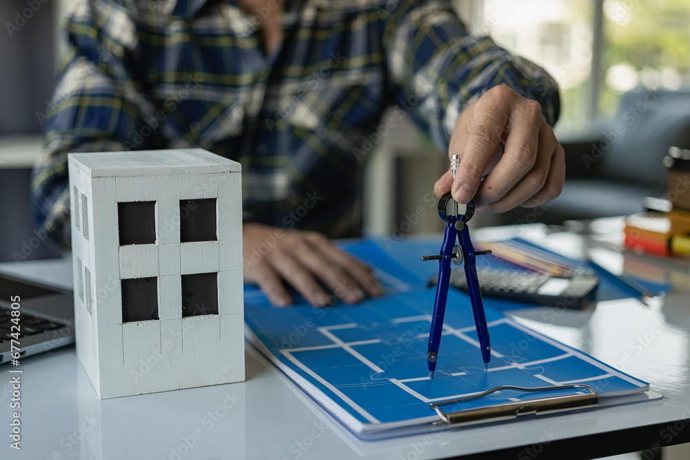 architects hands drawing of modern house with material sample on ...