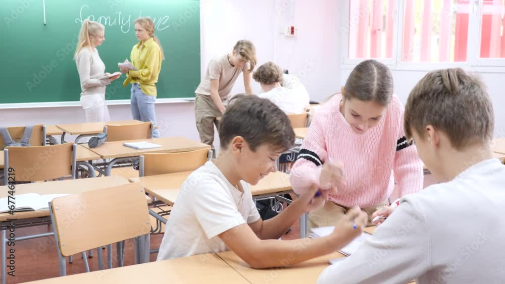 Group of diligent school kids discussing something in group during ...