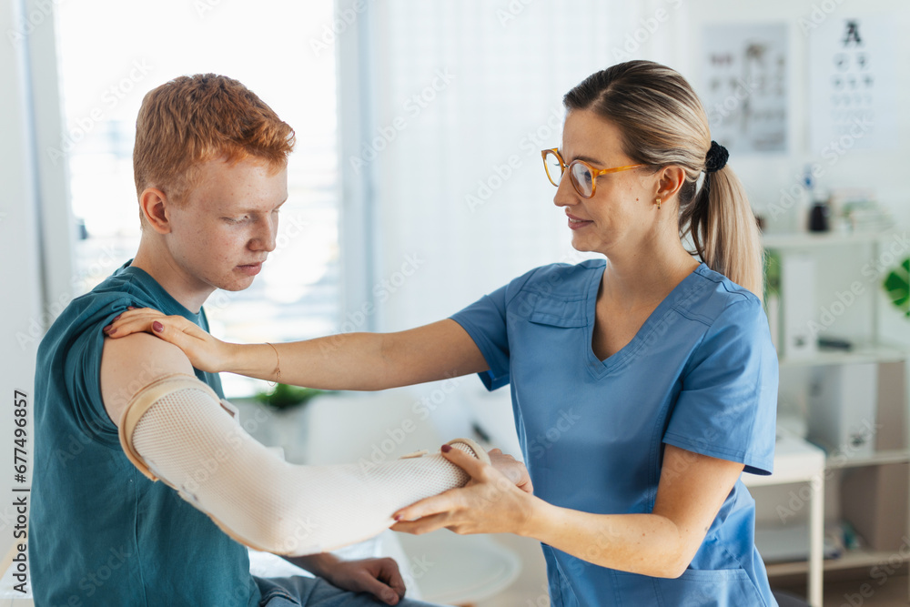 Doctor checking the orthopedic cast, brace on a teenage patient's ...