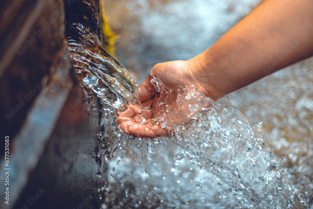 Beautiful photo of a hand under a stream of clear spring water. The ...