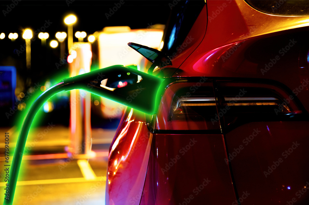 An EV Electric vehicle with a glowing charging cable plugged in. A ...