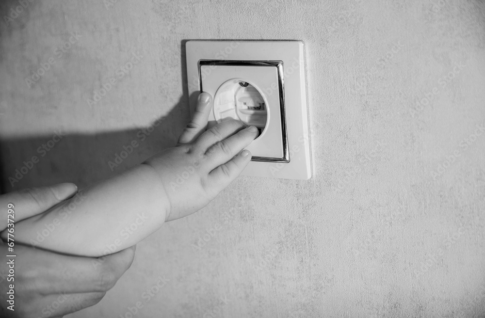 The child touches the electrical outlet with his hand. Electric shock ...