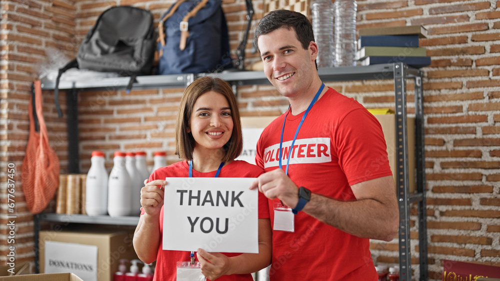 Man and woman volunteers standing together holding paper with thank you ...