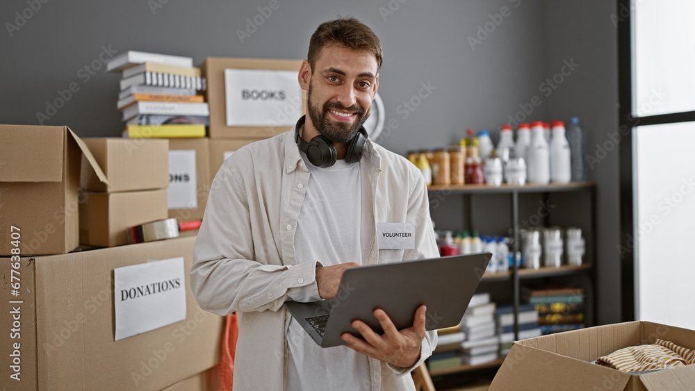 Beaming young hispanic man working away confidently at the charity ...