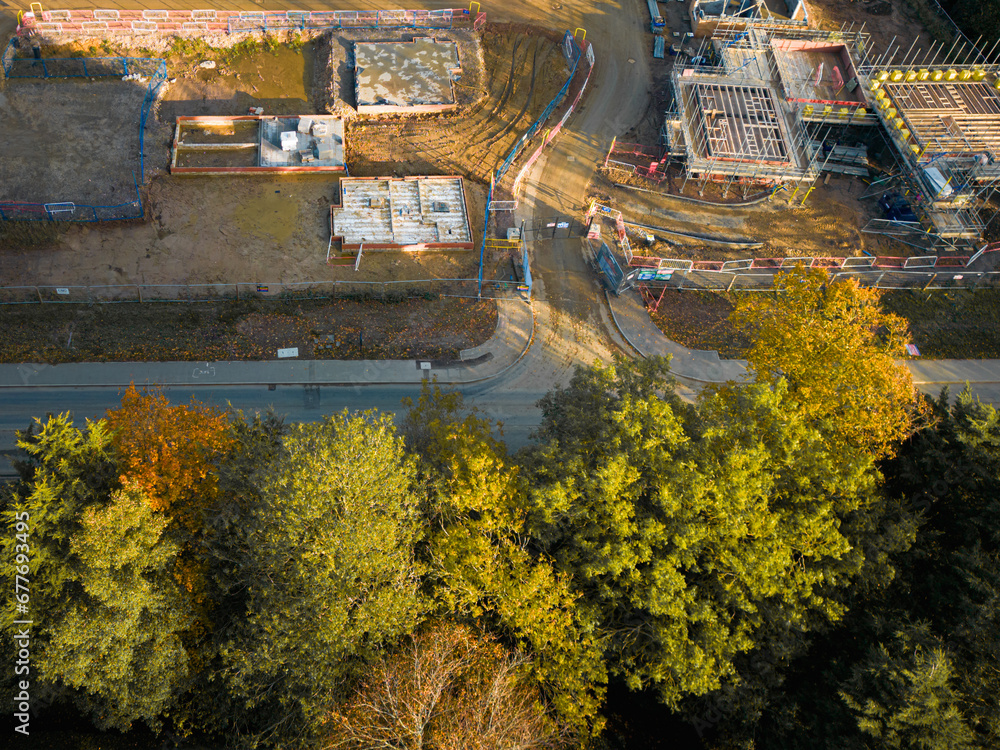 Seen above autumn trees, a English housing development project with ...