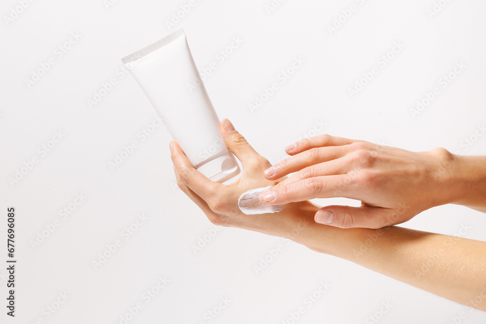Female hand holding white mockup tube of cream or lotion and applying ...