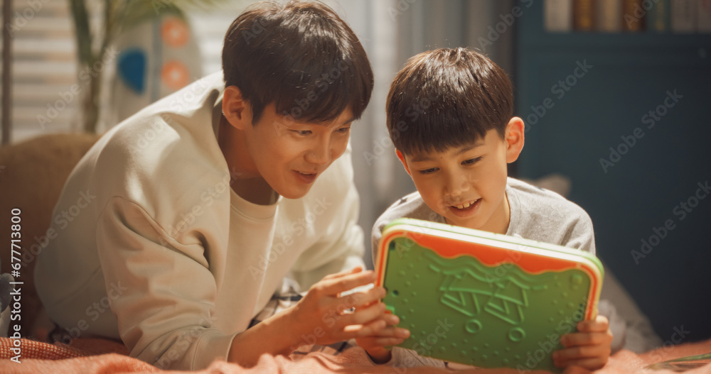 Portrait of Father and Son Playing Video Games on a Digital Tablet at ...