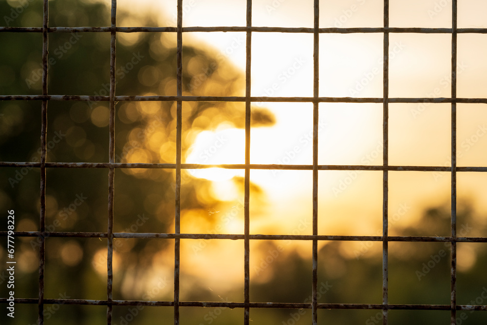 A view through the bars of the sunset and the sunlight falling on the ...