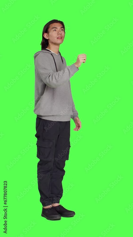 Side view of male model looks at hologram icon on camera with full body ...