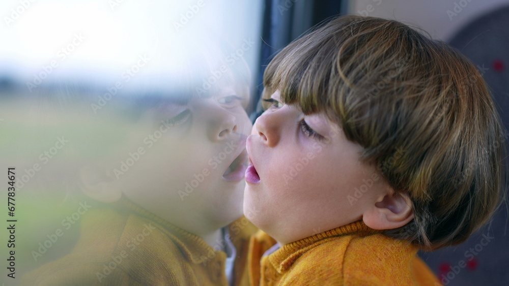 Bored funny small boy with face glued on trian window. Mouth and lips ...