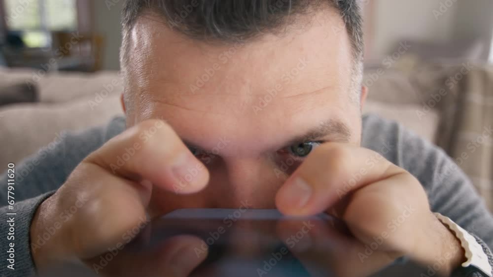 Close up funny male scrolling mobile screen using both thumbs and ...
