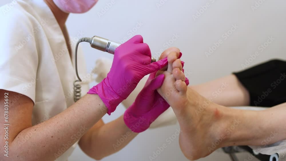 Pedicure master in medicine mask making pedicure of feet. Woman legs In ...