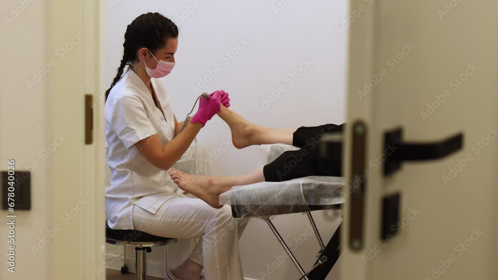 Stockvideon Pedicure master in medicine mask making pedicure of feet ...
