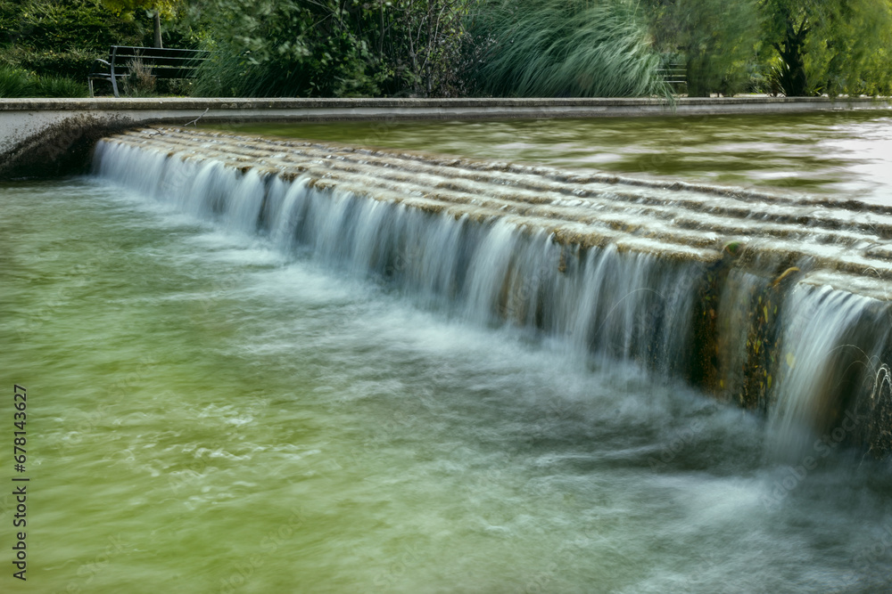 Long exposure image of a small slope with water falling into a canal in ...