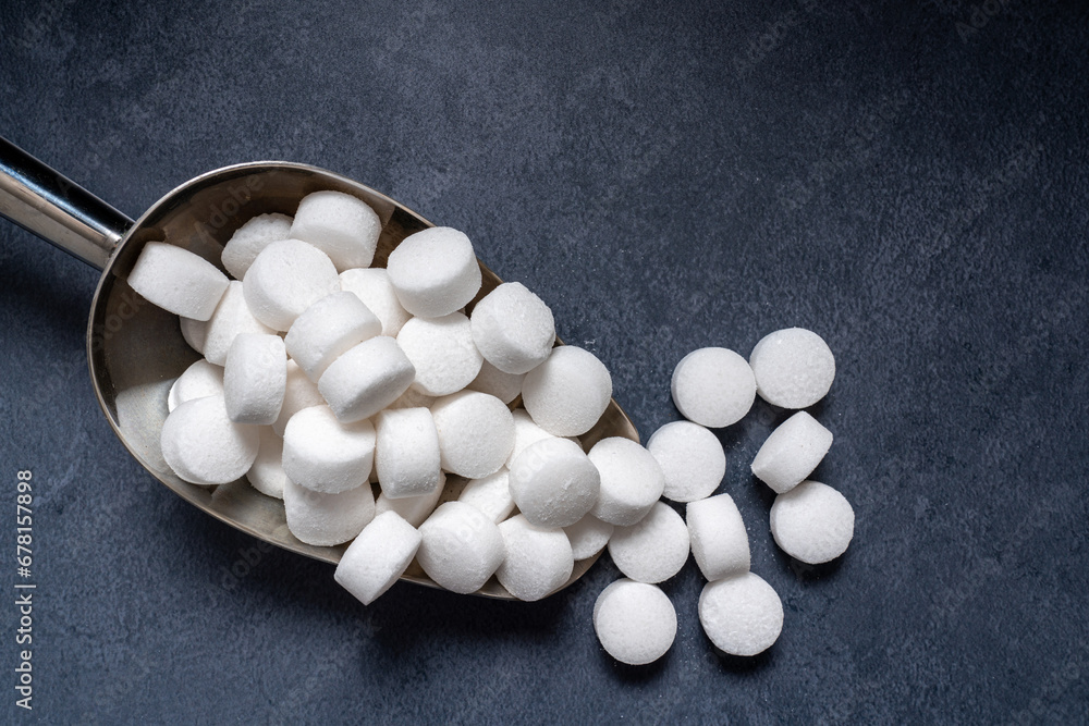 Round white sea salt tablets used in a water treatment appliance or ...